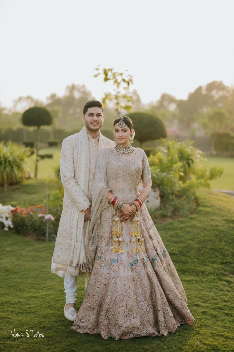 Photo of Lovely couple portrait with the bride in a pastel lehenga with ...