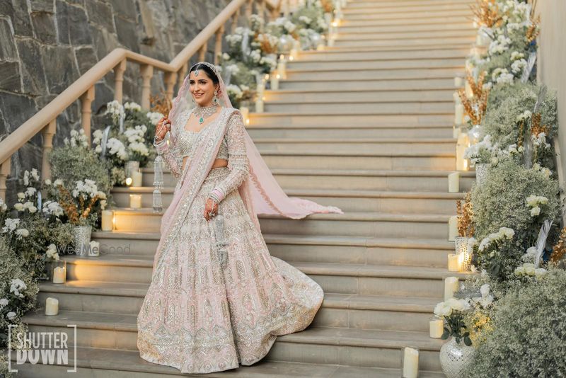 Photo of Bride walking down the stairs in a stunning white and pink ...