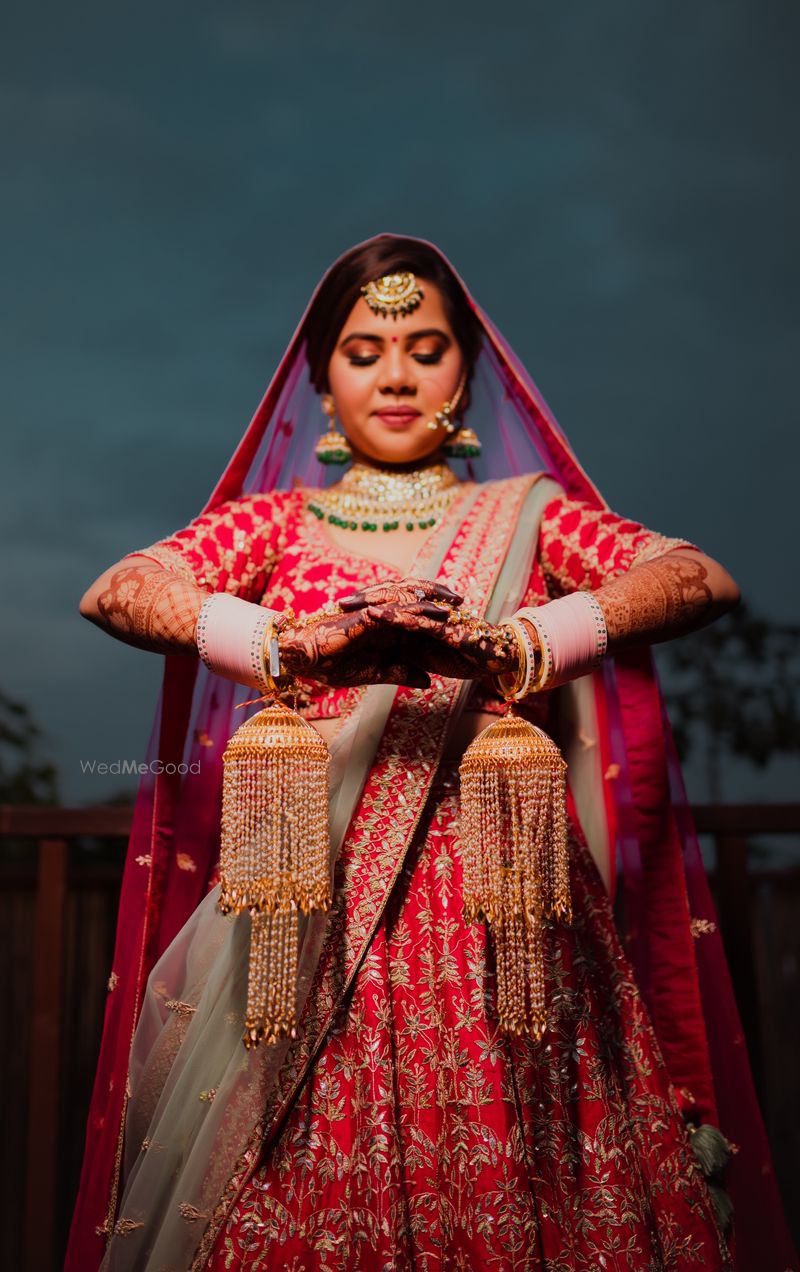 Photo of bride wearing a red lehenga and pastel chooda