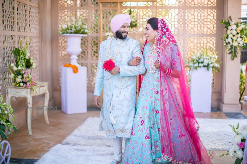 Photo of matching bride and groom in powder blue outfits