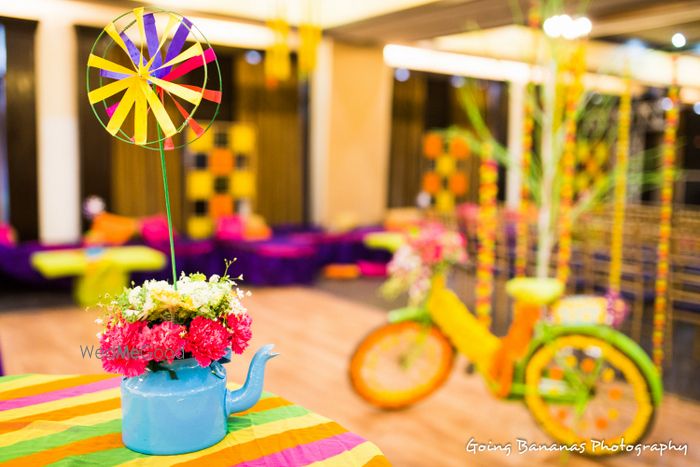 Photo of blue tea kettle with windmill and bicycle prop for funky