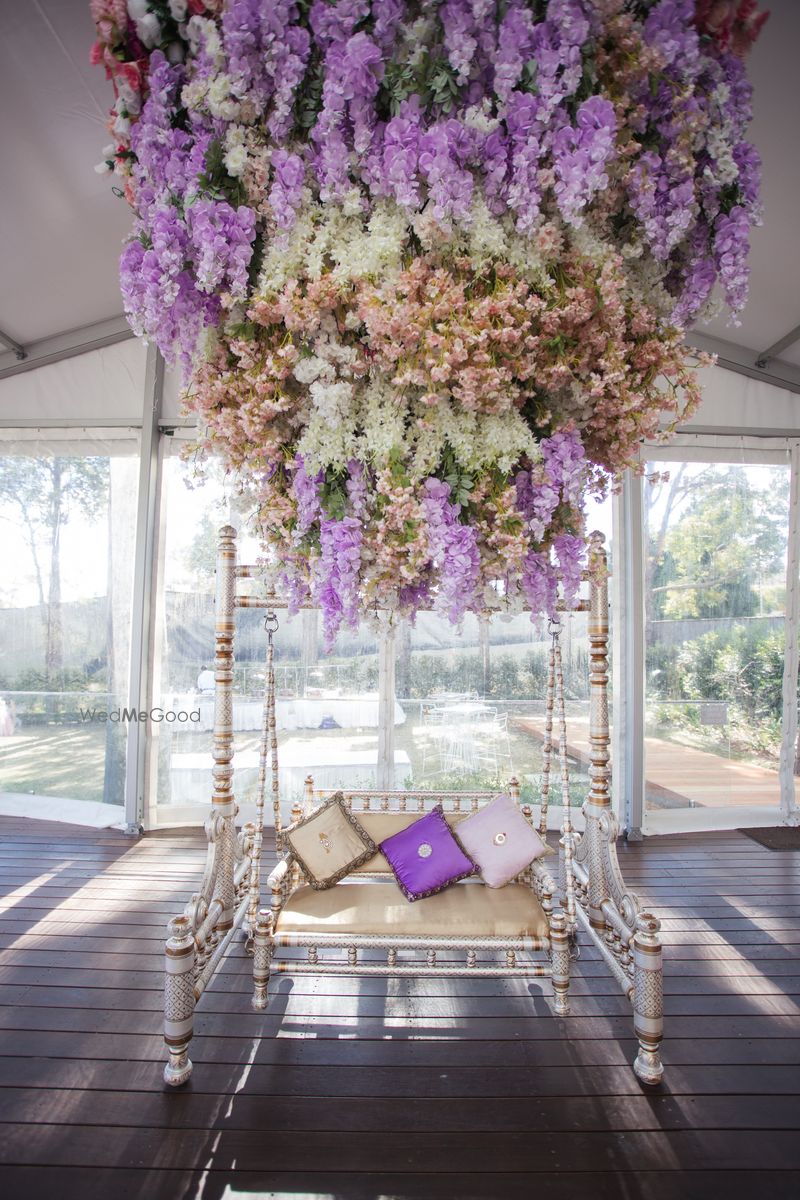 Photo of A Jhoola seating with floral ceiling decor for the Mehendi.