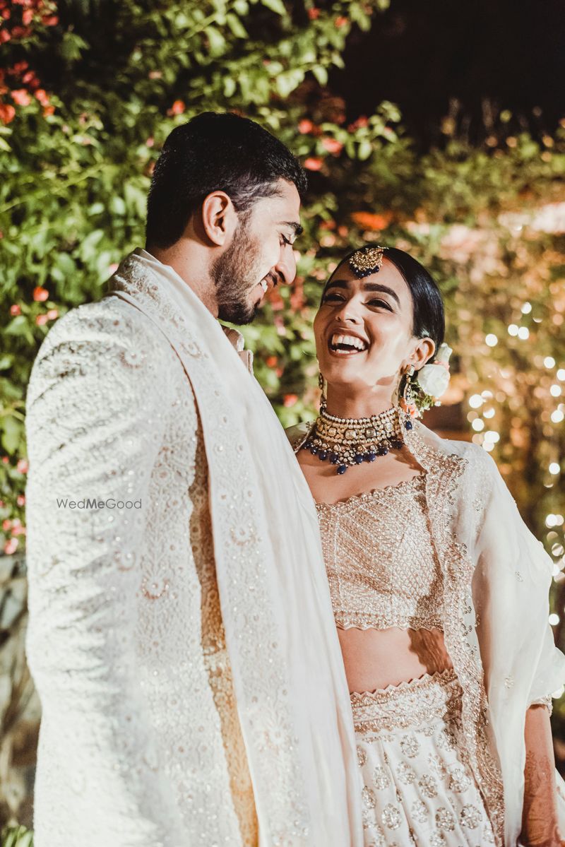 Photo of matching bride and groom in ivory and gold after wedding