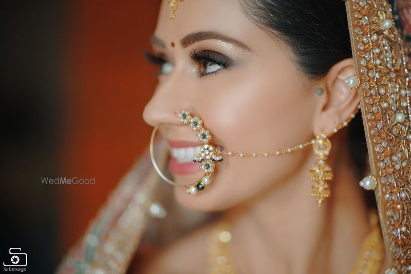 Photo of A bridal nath with floral motifs and pearls.