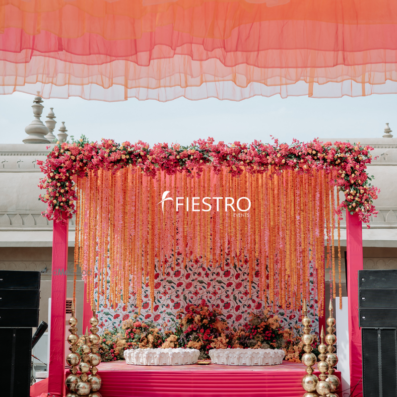 Photo of Haldi decor for seating in pink and orange hues with hanging ...