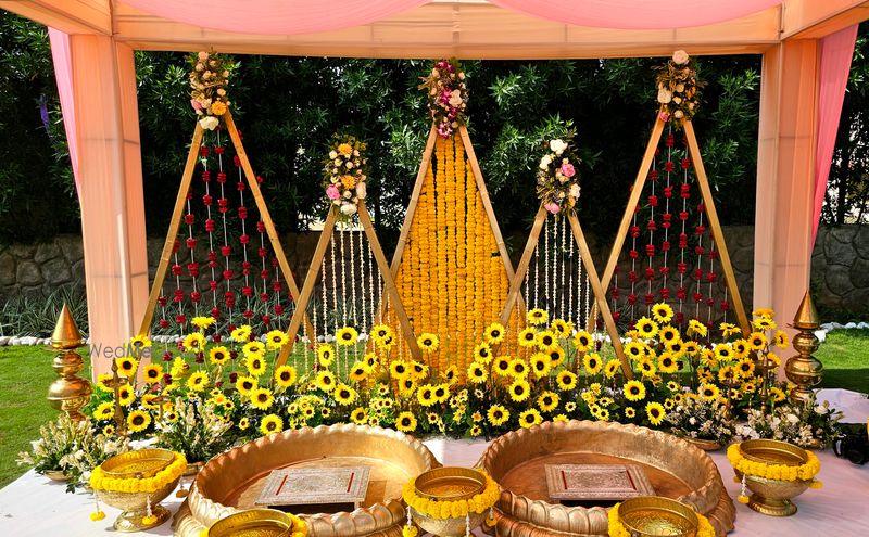 Photo of Lovely haldi seating set up for the bride and groom with gold ...