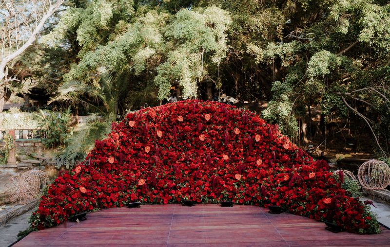 Photo of Stunning reception stage decor with a statement all red floral ...