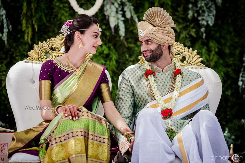 Photo of South Indian bride and groom looking at each other and posing.