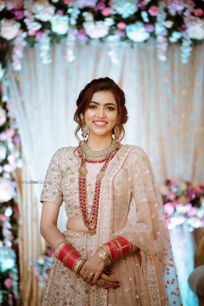 Photo of bride in a pastel lehenga with contrasting jewellery