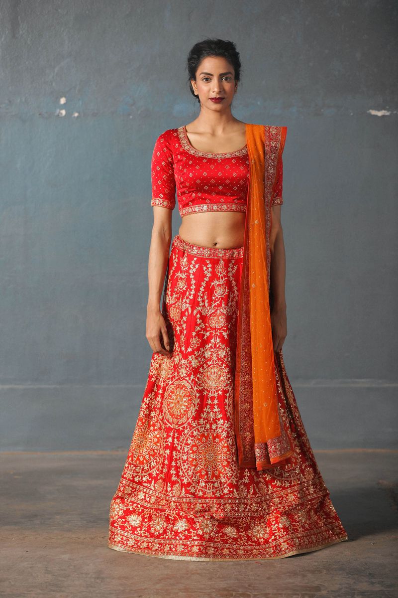 Bright red and orange embellished lehenga by Ritu Kumar